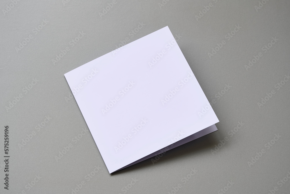 Laying blank closed empty square greeting card mock up on grey ...