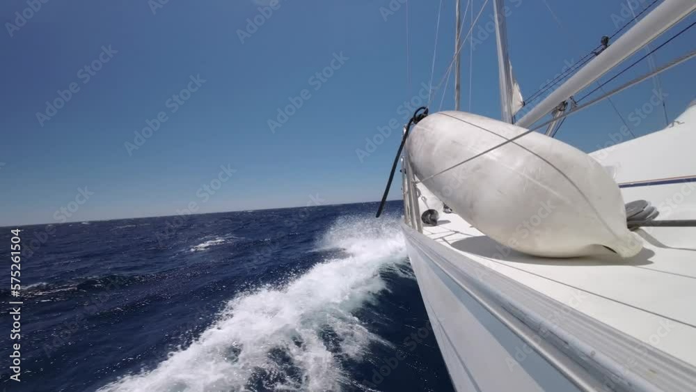 Floating sailing yacht with spread sails splitting the sea waves and an ...