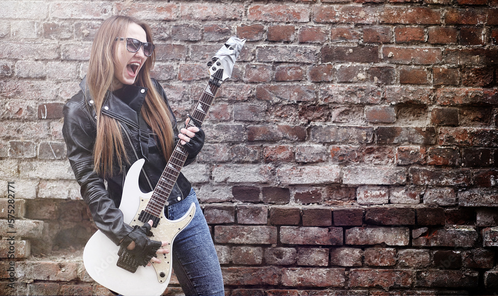 Beautiful young girl rocker with electric guitar. A rock musician girl ...