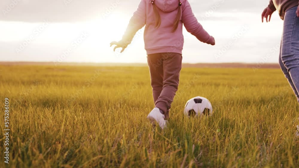 little child with his father plays soccer ball field sunset. childhood ...