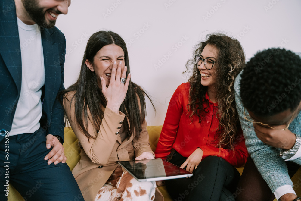 Multiracial colleagues burst out laughing after joking each other while ...
