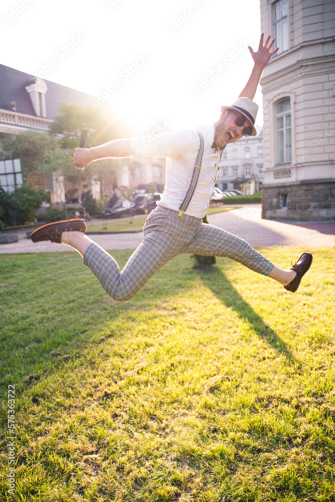 handsome presenter and showman in a stylish suit and hat with a ...