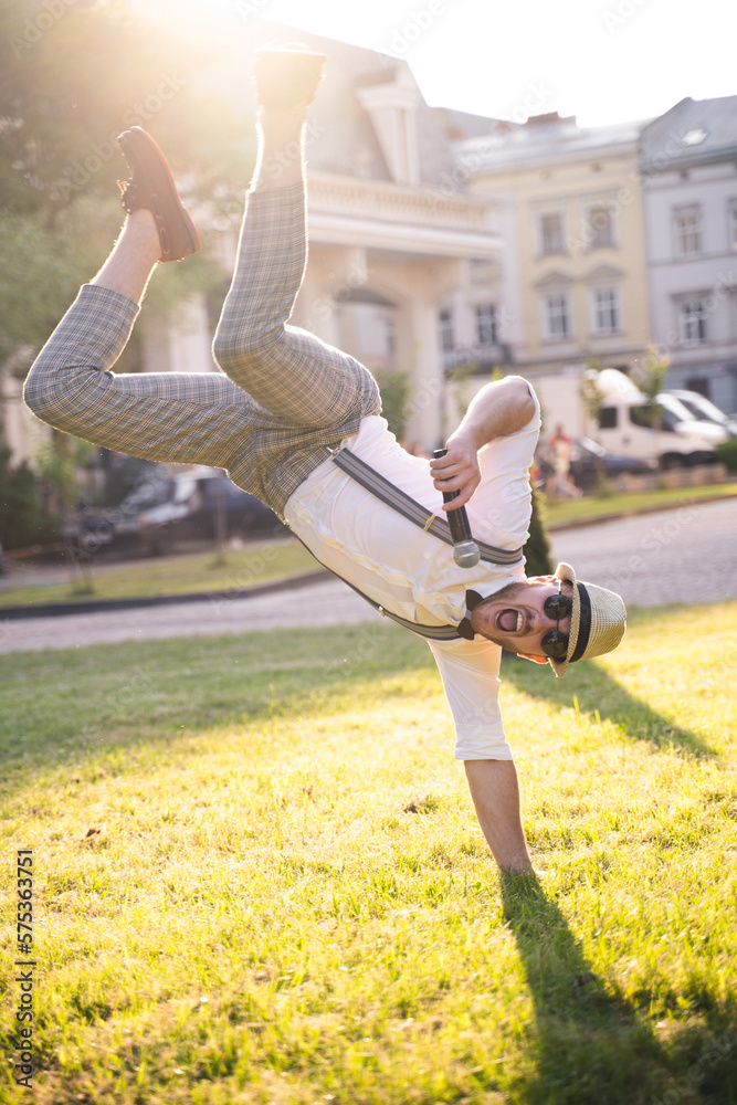 handsome presenter and showman in a stylish suit and hat with a ...