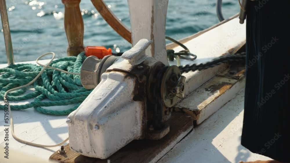 Close-up of the anchor chain sliding on the pulley as the anchor is ...