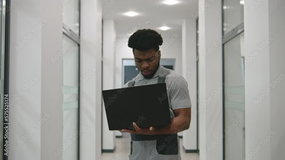 Vidéo Stock African American installer in uniform stands in corridor ...