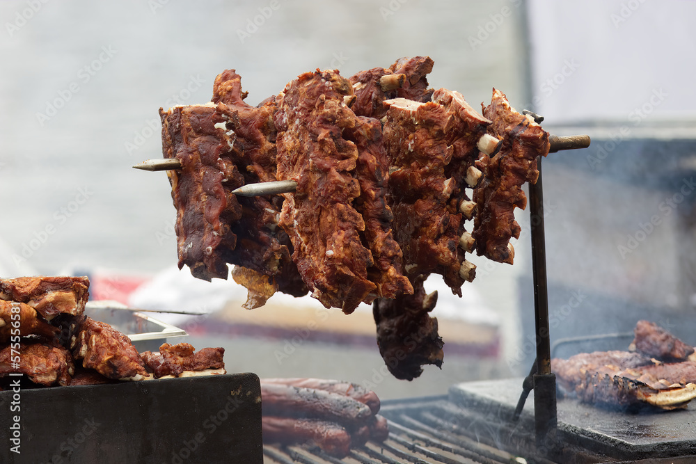 Local butchers stand with ribs and other meats ready for grilling at ...