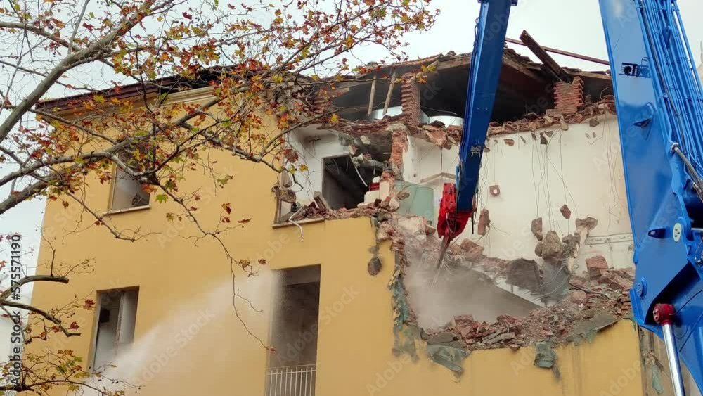 destruction of a structure with mechanical excavator on a building site ...