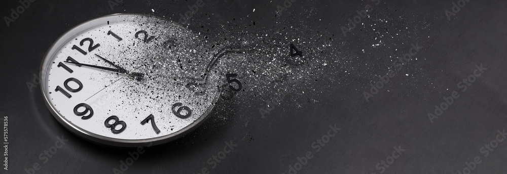 Flow of time. Analog clock dissolving on black background, space for ...