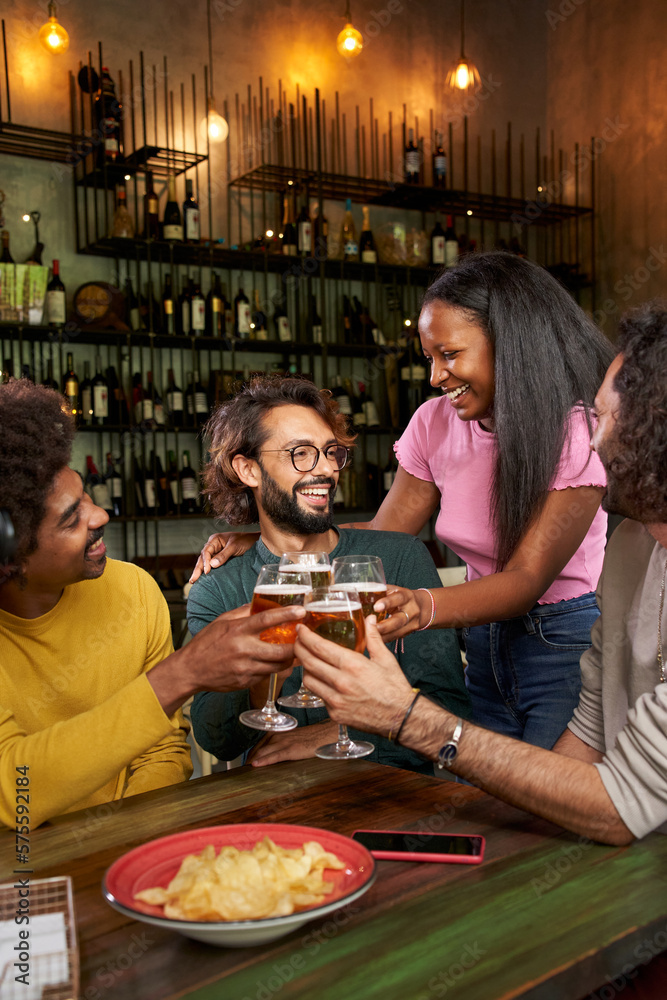 Vertical photo of group co-workers toast with beer at the restaurant ...