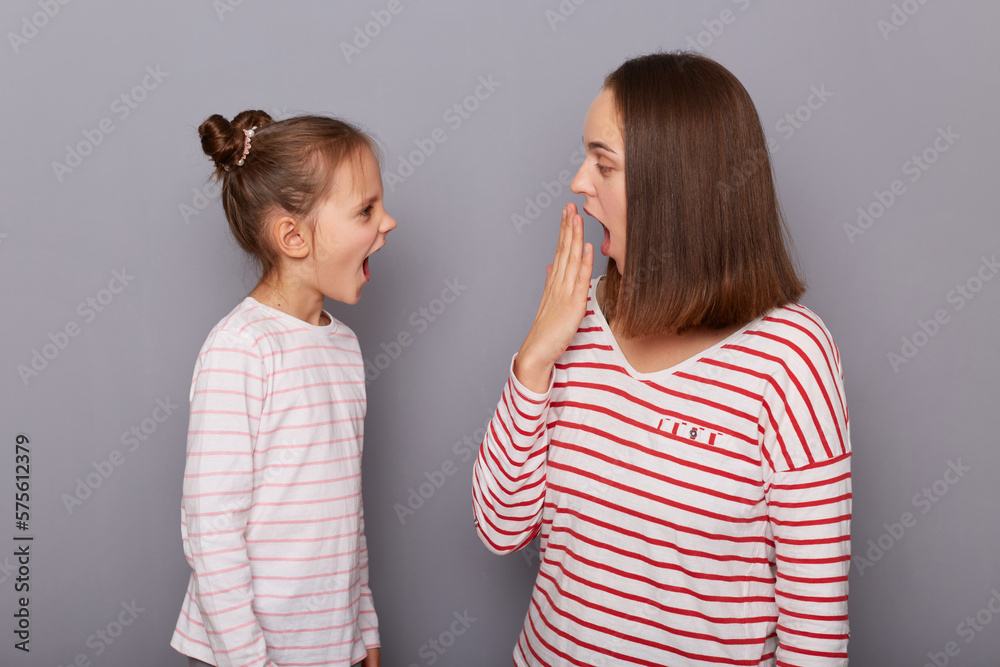 Indoor shot of shocked amazed mother and screaming daughter wearing ...
