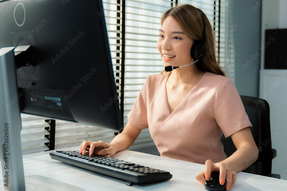 Competent female operator working on computer and while talking with ...