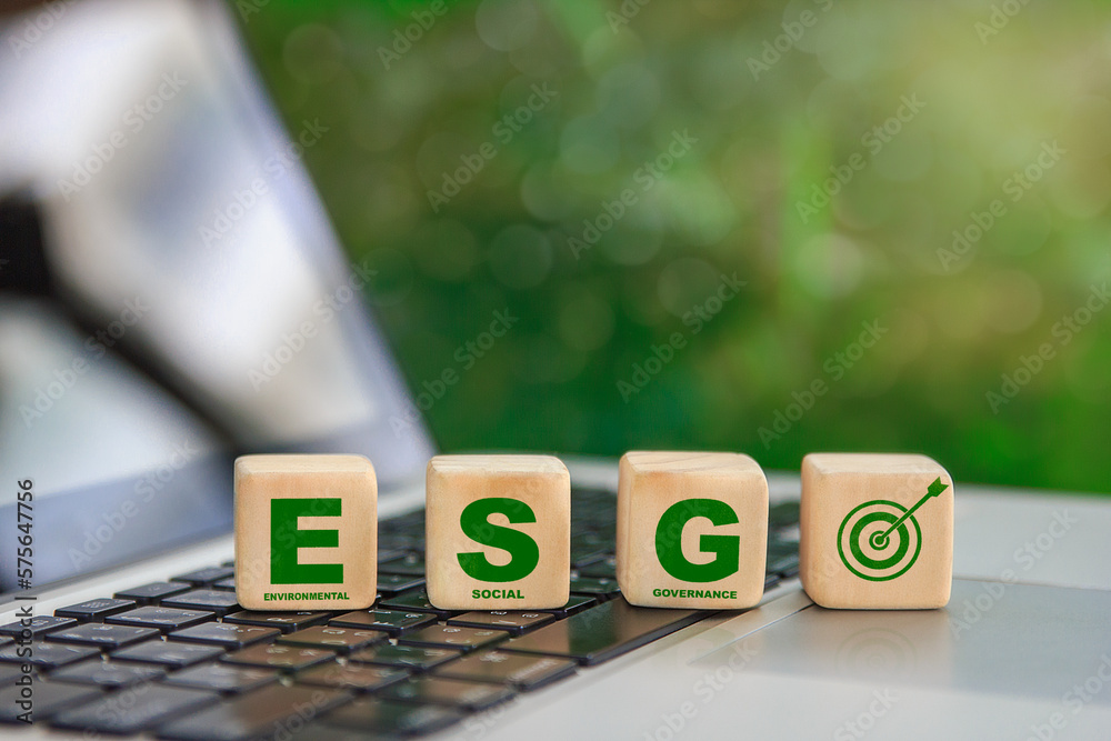 Wooden block with word ESG lies on computer keyboard with green ...