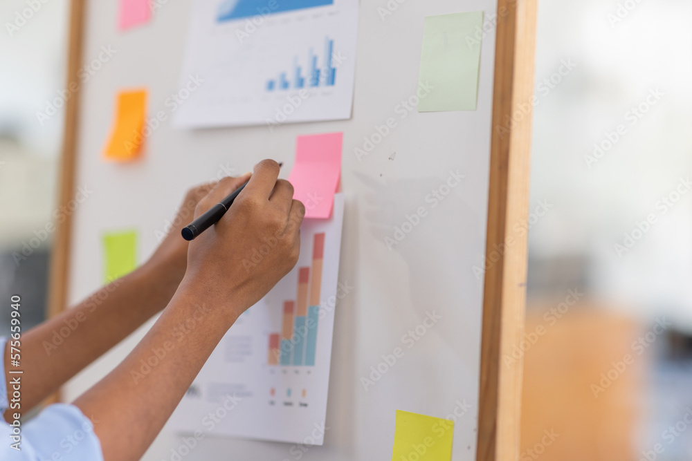 young asian entrepreneur of small company putting a adhesive sticky ...