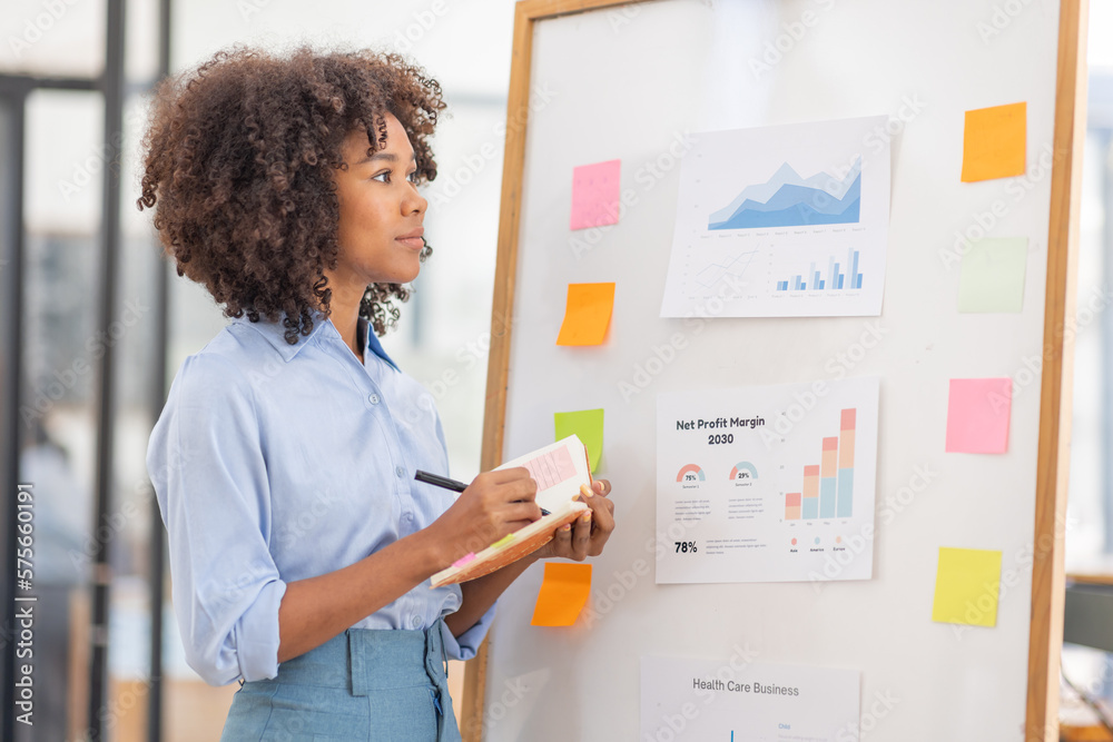 young asian entrepreneur of small company putting a adhesive sticky ...
