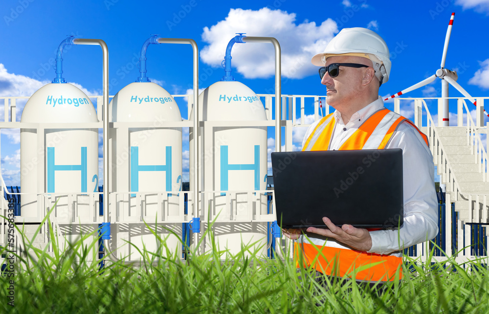 Hydrogen power plant technologist. Man with laptop near hydrogen plant ...