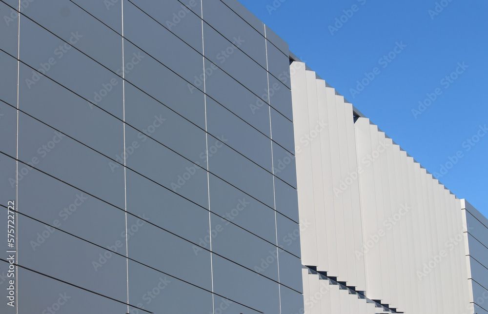 Abstract image of a new building with silver cladding and shade ...