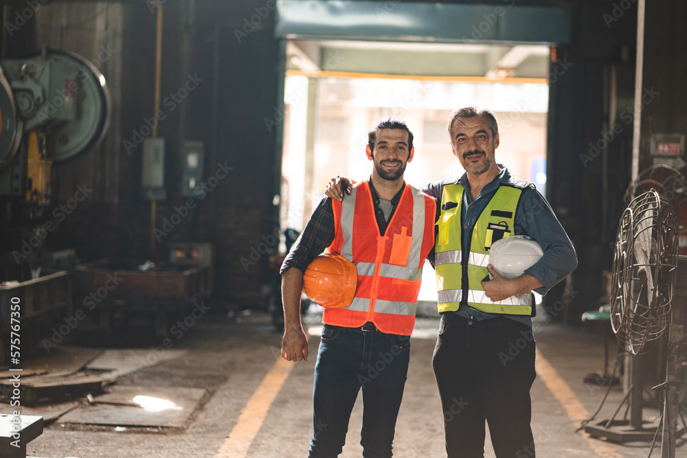 Portrait of senior and young male engineers and workers wearing safety ...