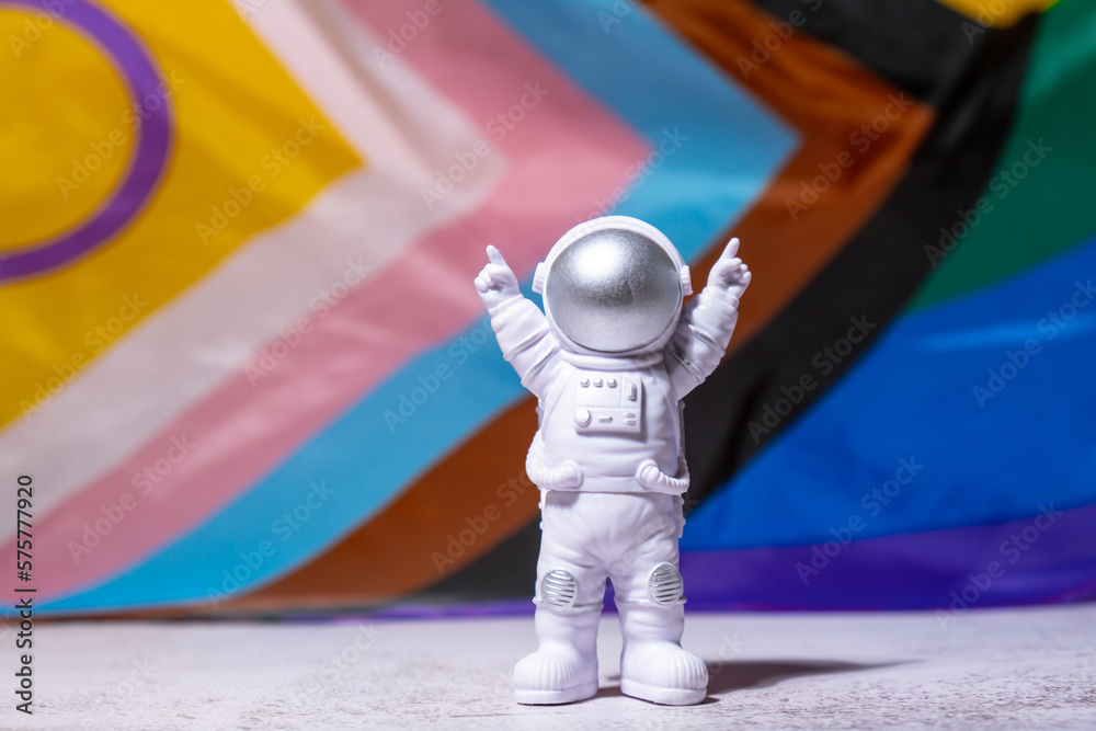Toy astronaut on Rainbow LGBTQIA flag made from silk material ...