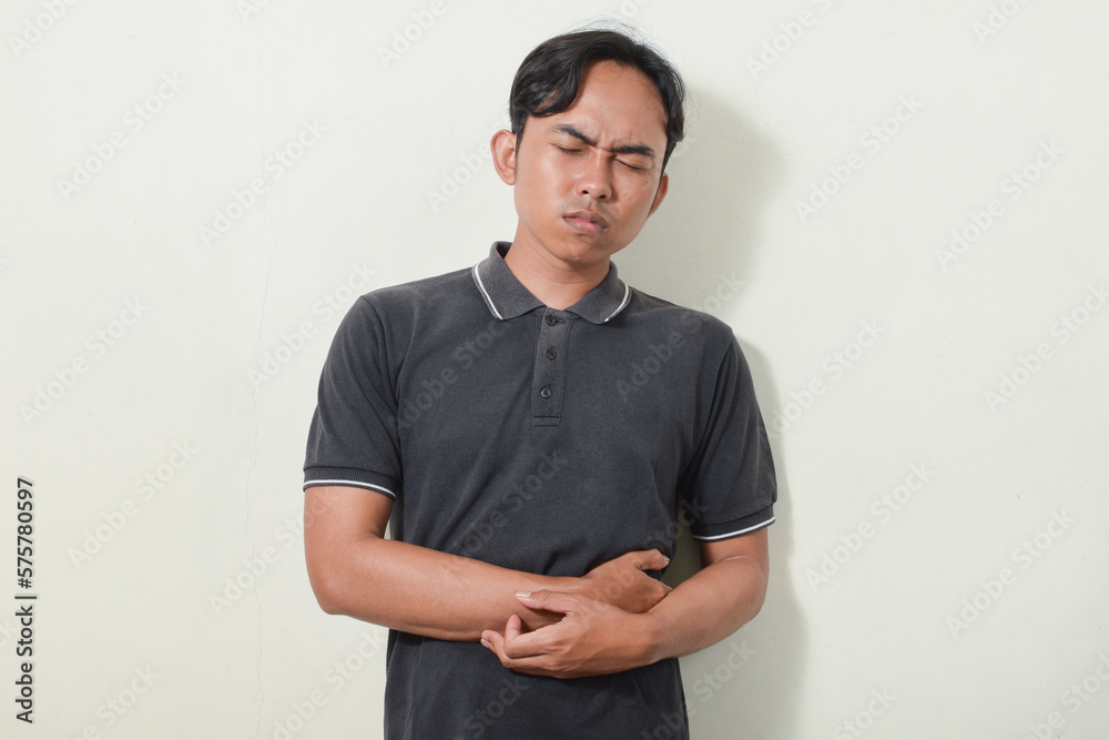 gesture of asian man stomach ache. Indonesian man poses holding the ...