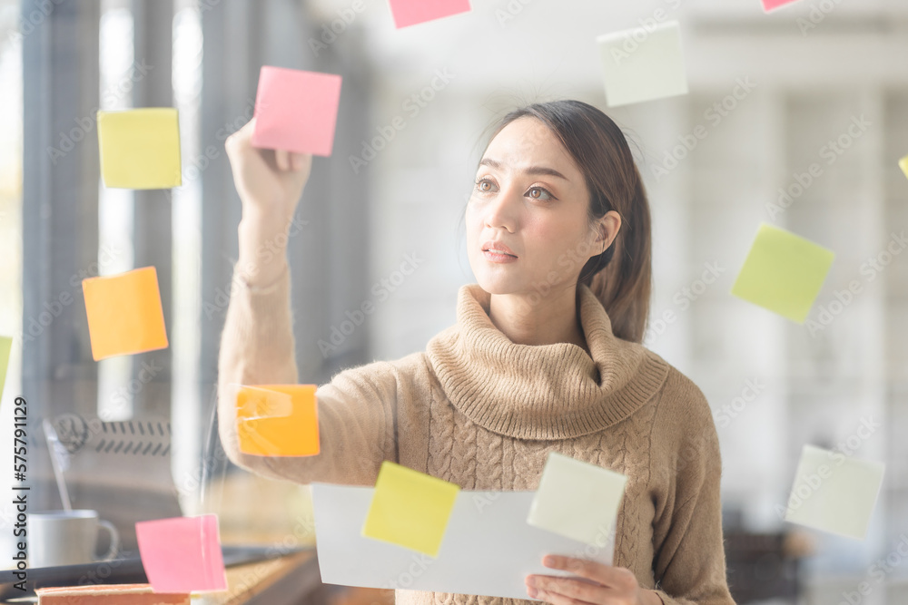 Business Asian woman meeting at office and use post it notes in glass ...