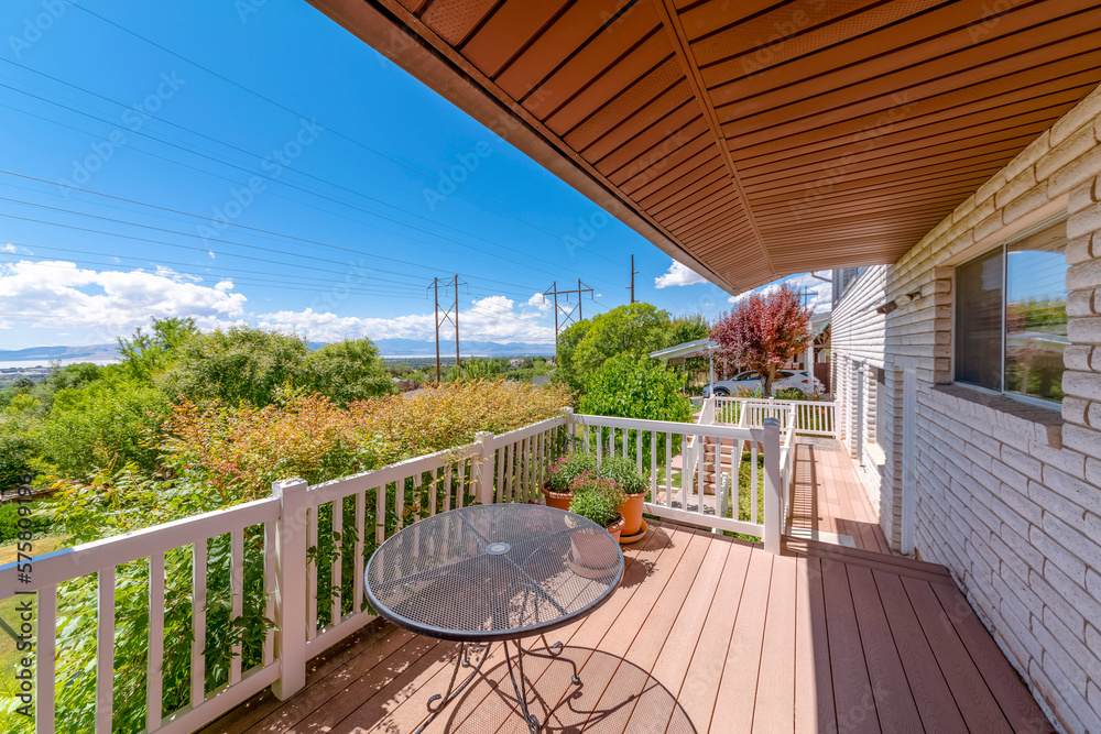 House veranda with round table near the railings and views of trees and ...