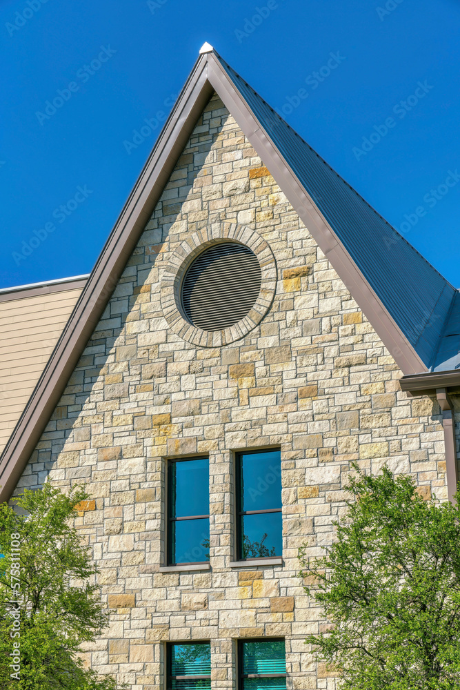Vertical shot of a french country home with round attic window and ...