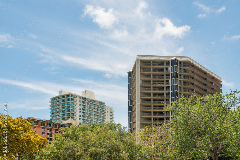 Residential buildings views from below with trees at front in Miami ...