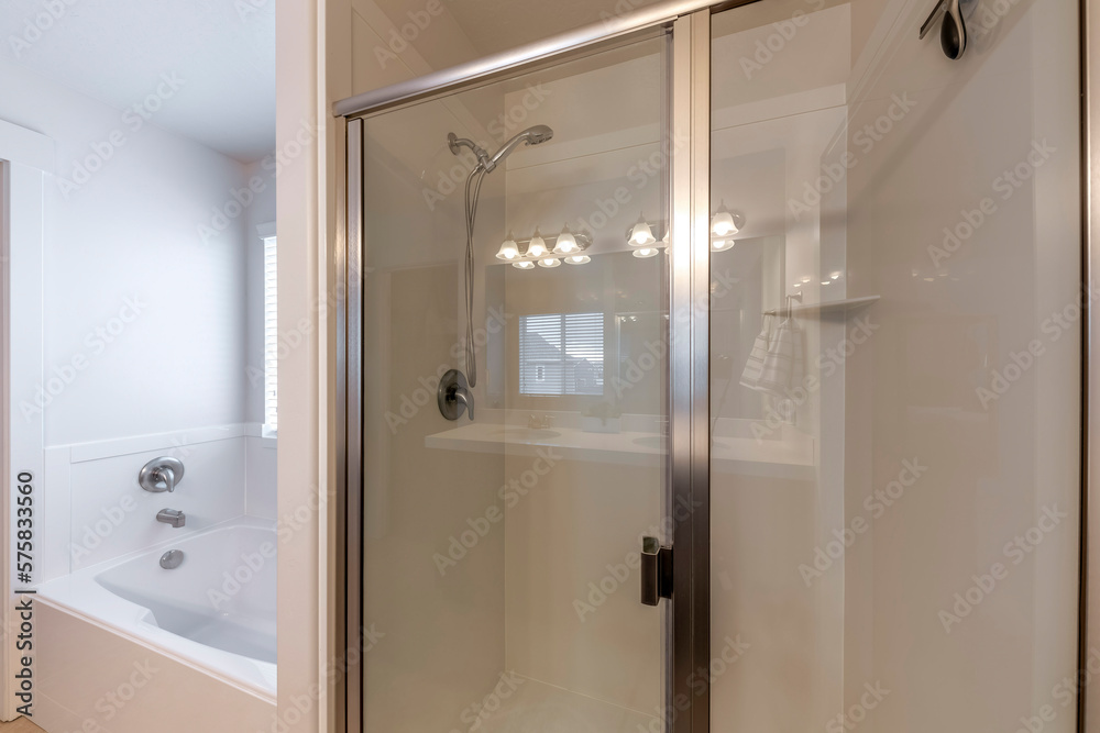 Shower stall with glass door and wall-mounted showerhead beside the ...