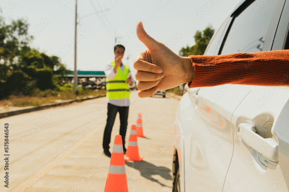 Young woman's hand showing thumb with transport driving license test ...