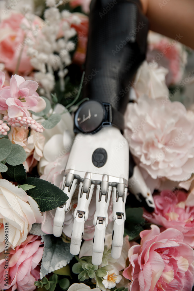 Bionic artificial hand prosthetic over pink flowers. Vertical selective ...