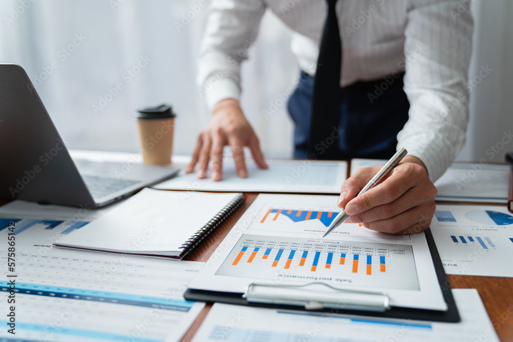 Foto de Young Asian businessmen sit analyzing data at the desk and ...