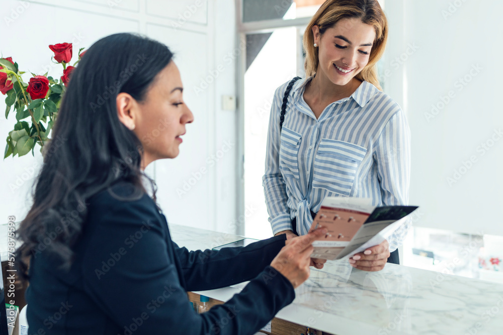 Receptionist showing flyer to customer Stock Photo | Adobe Stock