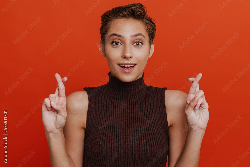 Young beautiful short-haired hopeful woman showing hope gesture crossed ...