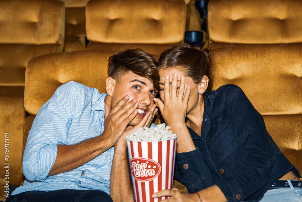 Caucasian couple holding popcorn sitting watching horror movie theater ...