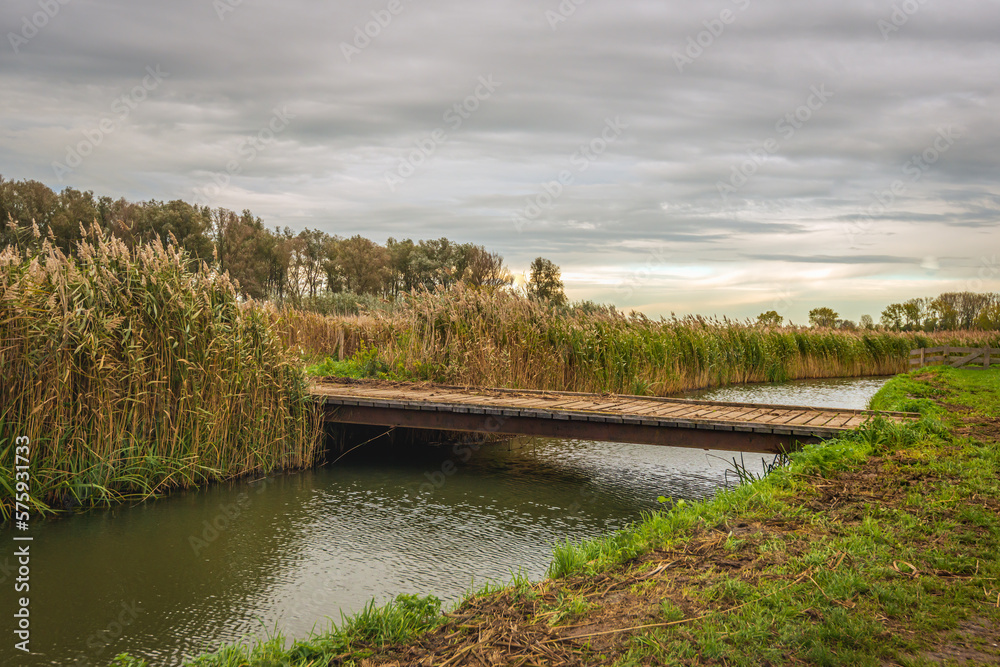 Stockfoto Simple bridge of steel beams and wooden planks over the water ...