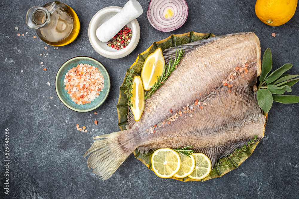 Raw flounder fish flatfish with lemon and spices on a dark background ...