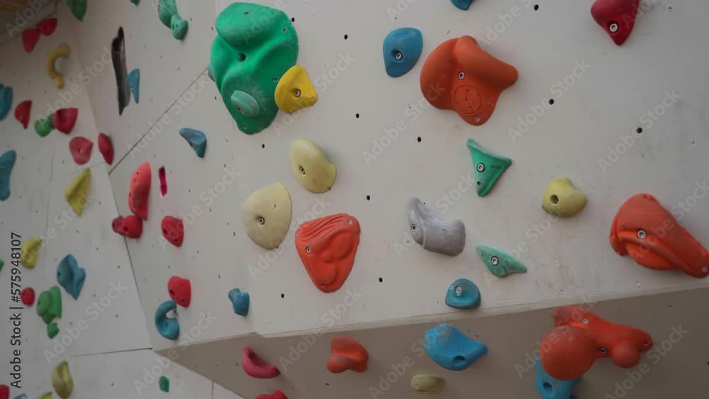 Climbing wall with grips in bouldering center. Wall of an empty indoor ...