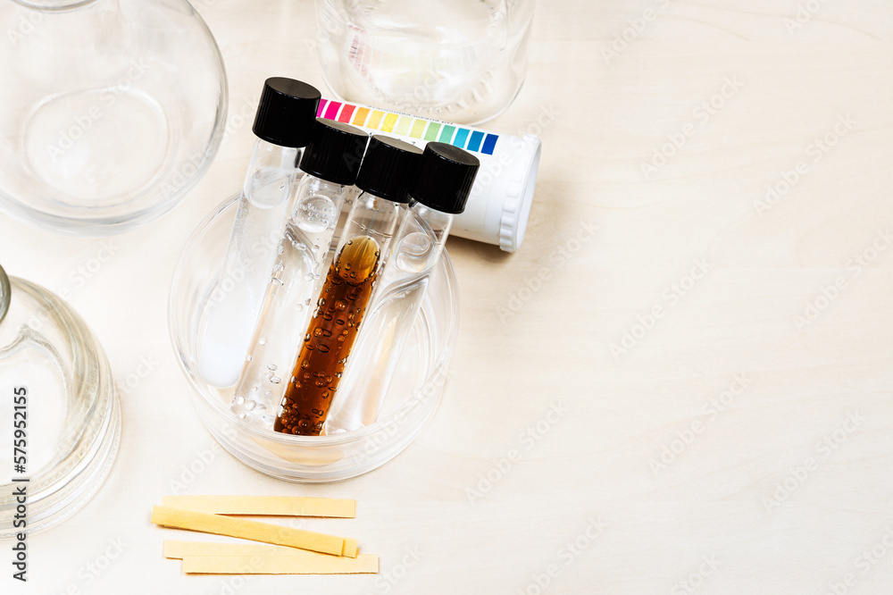 test tubes with various solutions, flasks and litmus papers on light ...