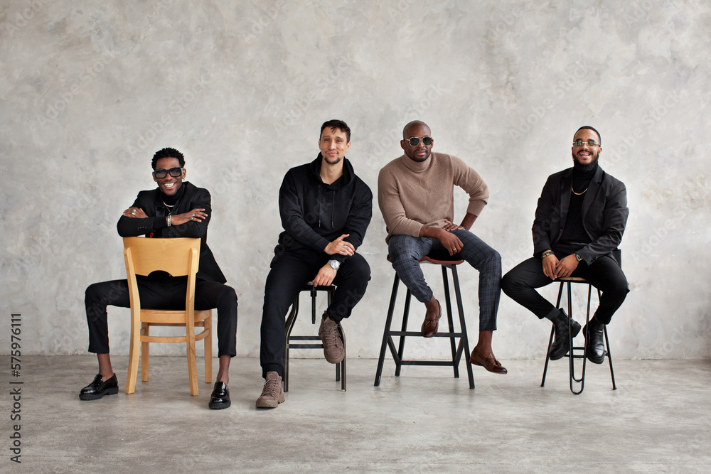 Young happy men against background of gray concrete wall. Multiethnic ...
