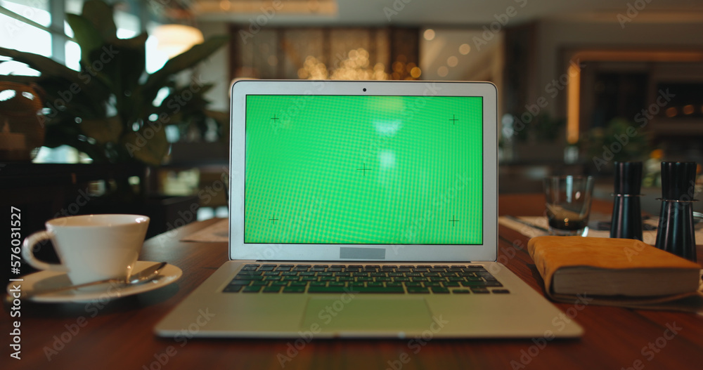 Laptop compuer with green chroma key mock up screen in office cafeteria ...