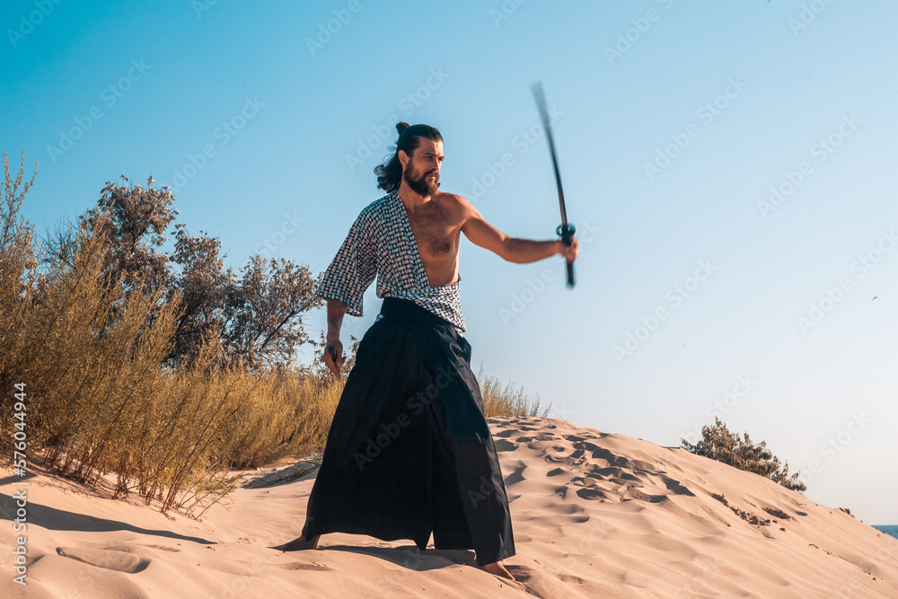 A Japanese warrior in a traditional kimano armed with a katana sword on ...