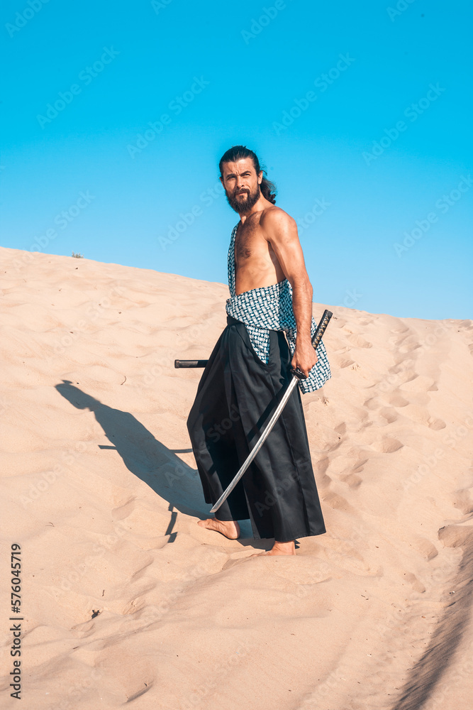 A Japanese warrior in a traditional kimano armed with a katana sword on ...