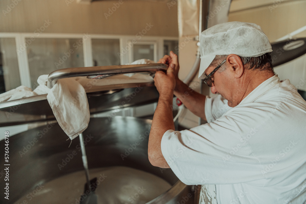 Man mixing milk in the stainless tank during the fermentation process ...