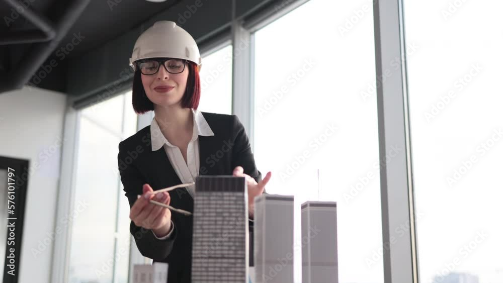 Qualified female architect or engineer in suit and hard hat measuring ...