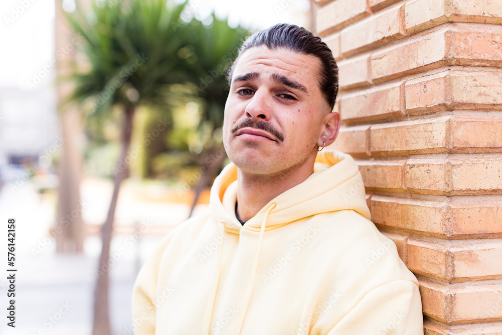 young cool man feeling sad and whiney with an unhappy look, crying with ...
