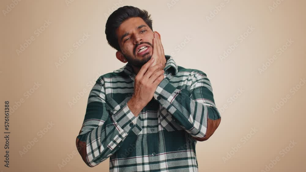 Indian bearded man touching sore cheek suffering from toothache ...