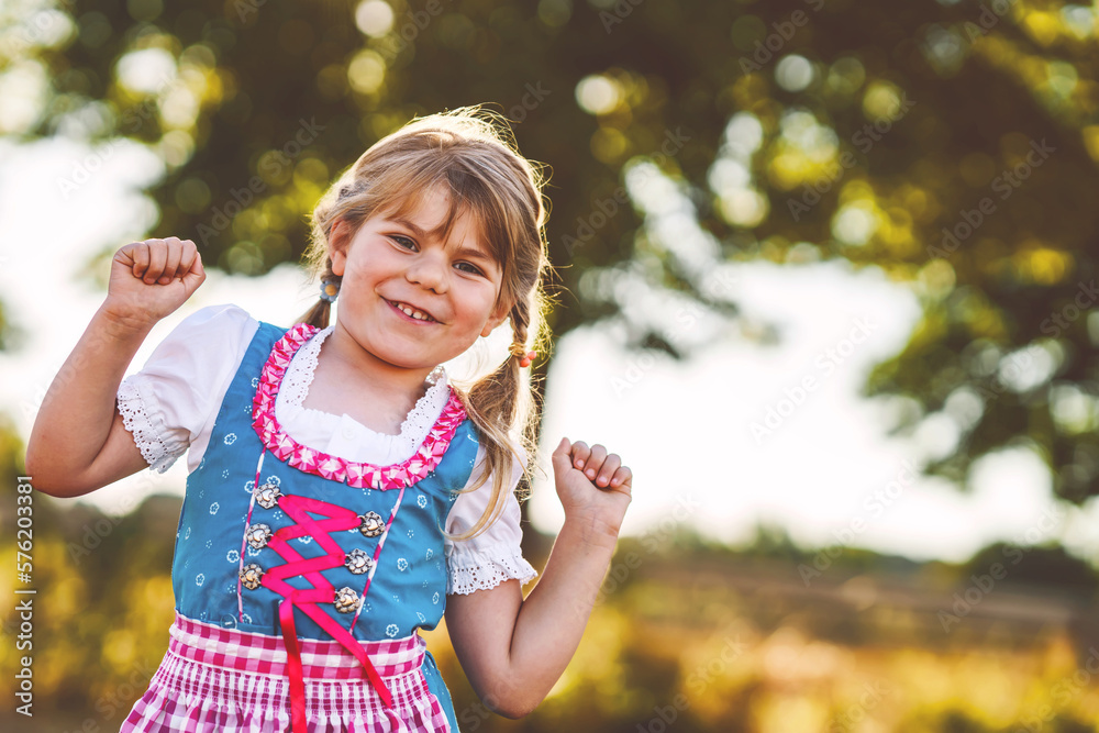 Cute little kid girl in traditional Bavarian costume in wheat field ...