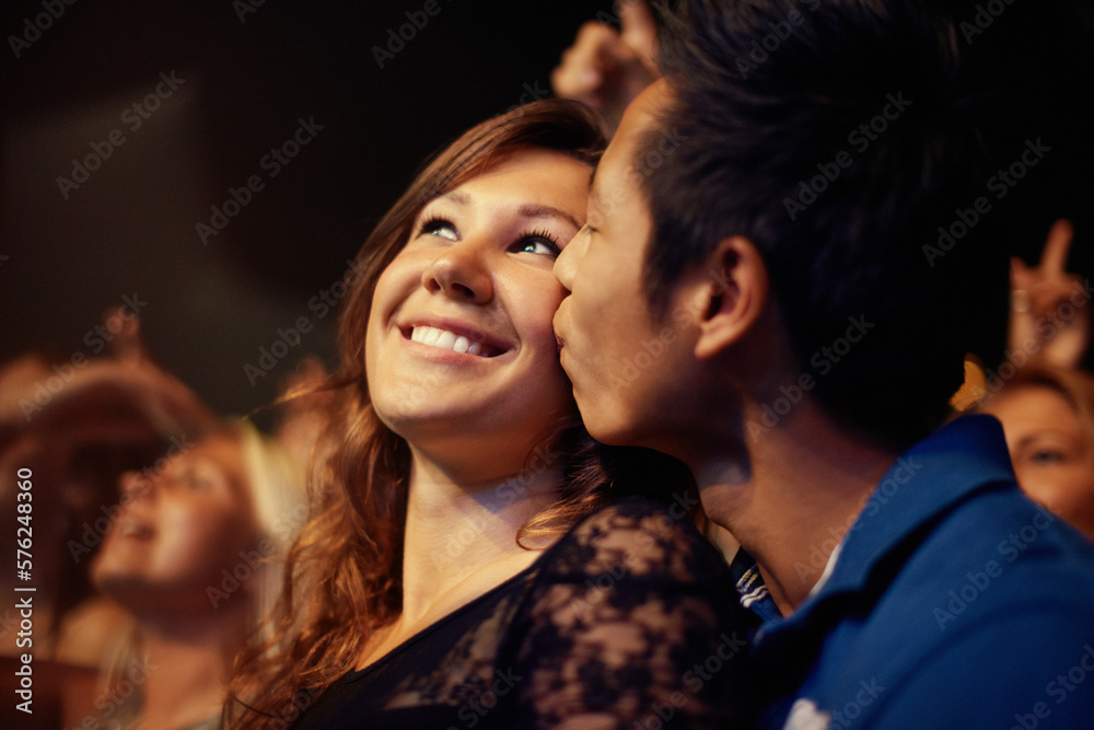 A young couple kissing at a rock concert. This concert was created for ...