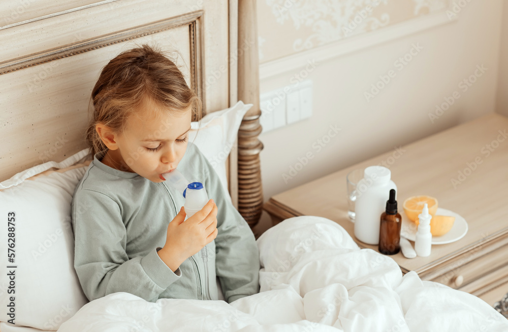Fotka „Little girl kid making inhalation with nebulizer at home at bed ...