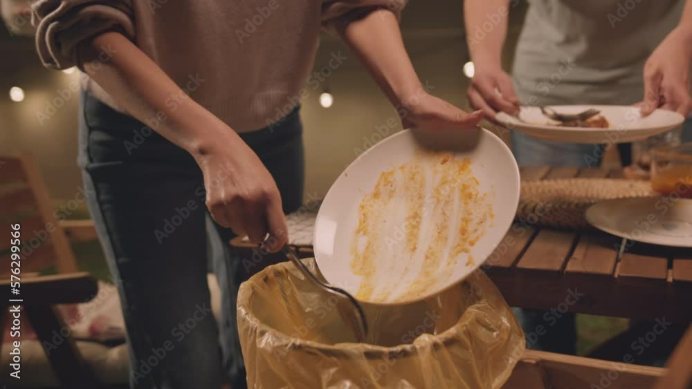 Group of people party at home after meal eating throw away leftovers ...